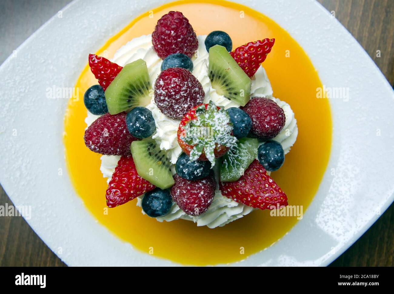 Mixed fruits with meringue, cream and orange coulis Stock Photo - Alamy
