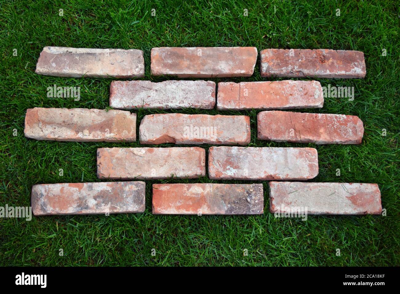 Cut red bricks range prepared to use design in the wall Stock Photo - Alamy