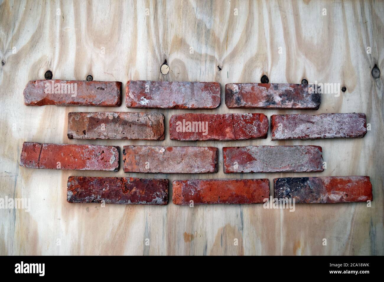 Cut red bricks range prepared to use design in the wall Stock Photo - Alamy