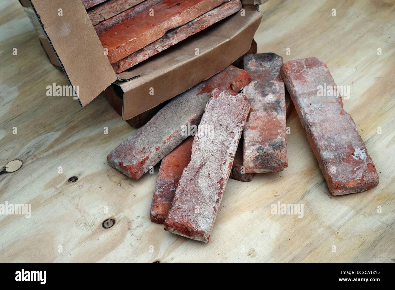 Cut red bricks range prepared to use design in the wall Stock Photo - Alamy