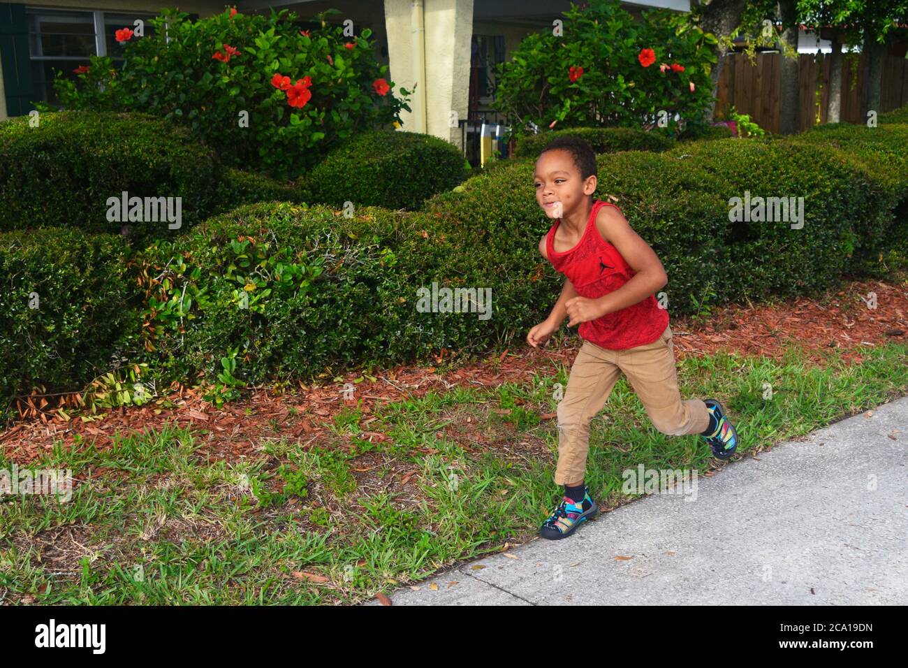 Young black boy running outside Stock Photo - Alamy