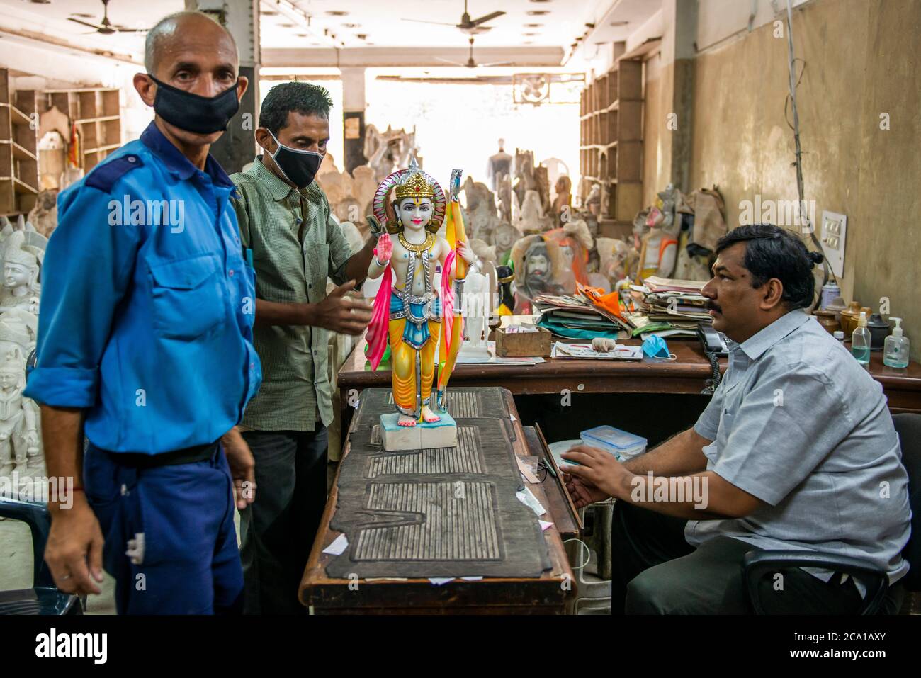 A man is seen holding a stone statue of Lord Rama carved with elegance ...