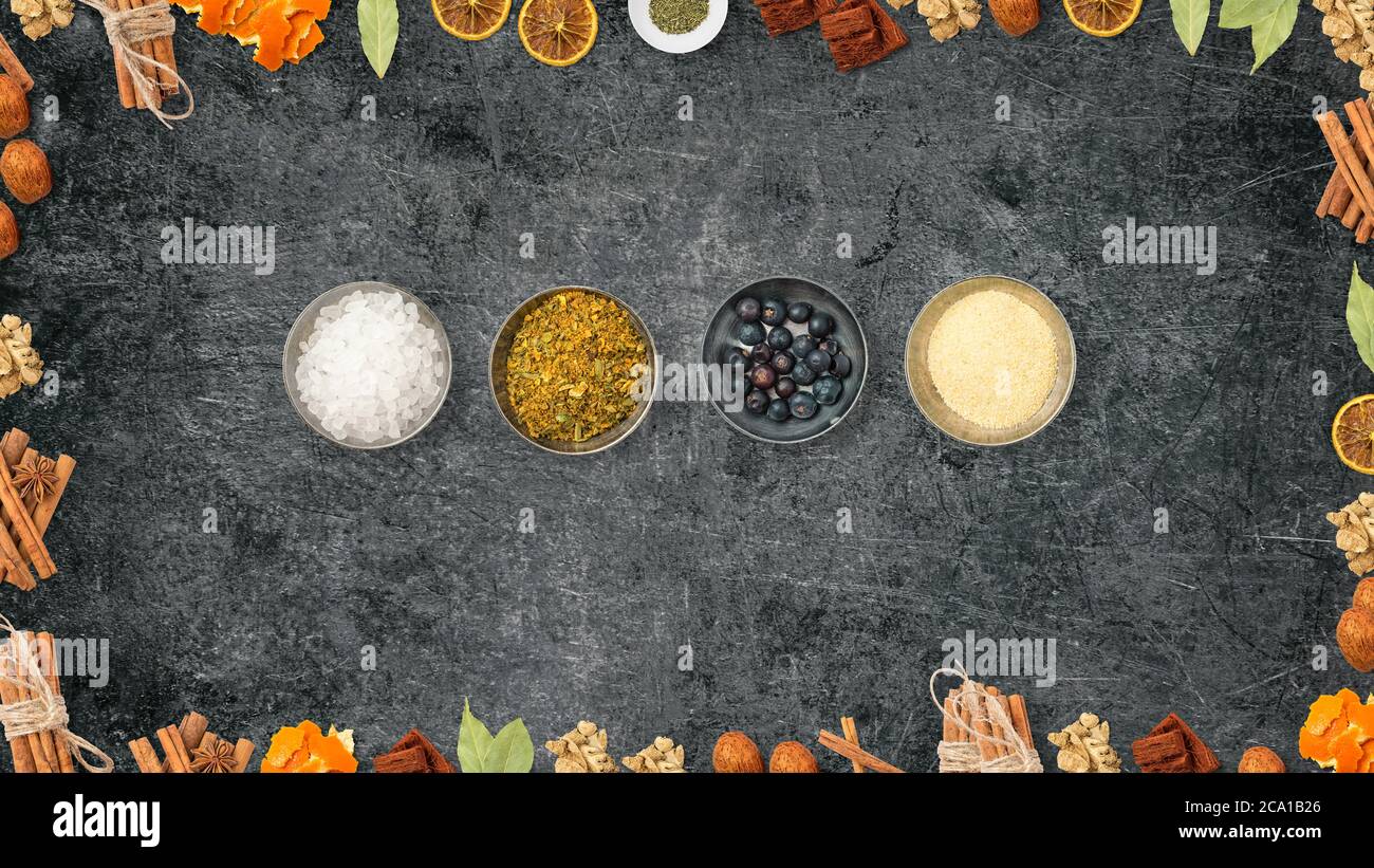 Herbs and spices like cinnamon, ginger and leaves over black stone ...