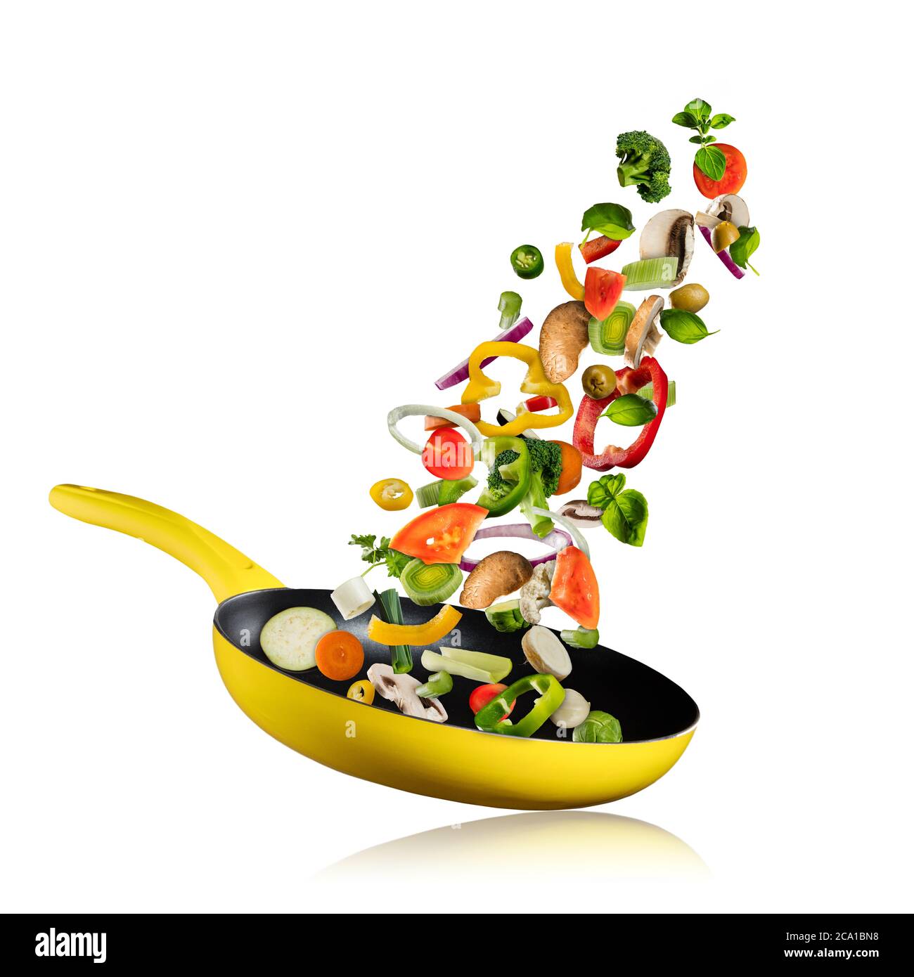 Fresh vegetables flying into a pan, isolated on white background ...