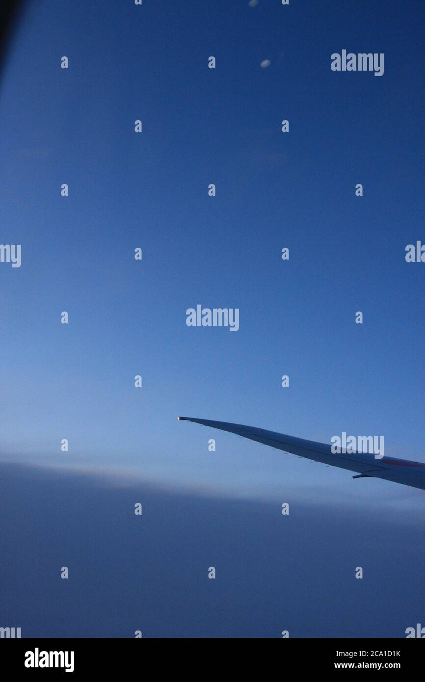 Airplane wing with dusk and deep blue sky on flight to Japan Stock ...