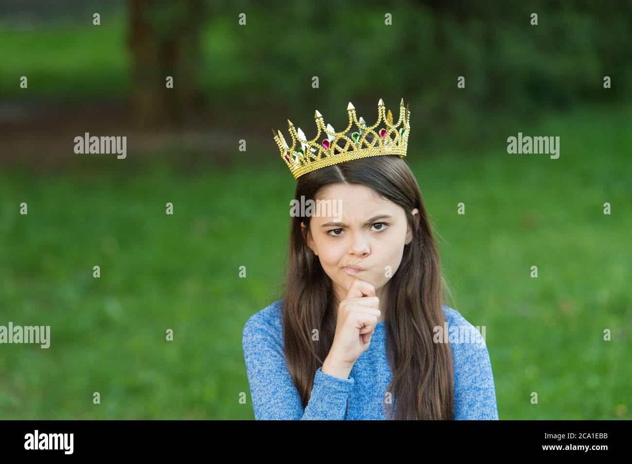 Cute girl golden crown outdoors green nature background, grumpy ...