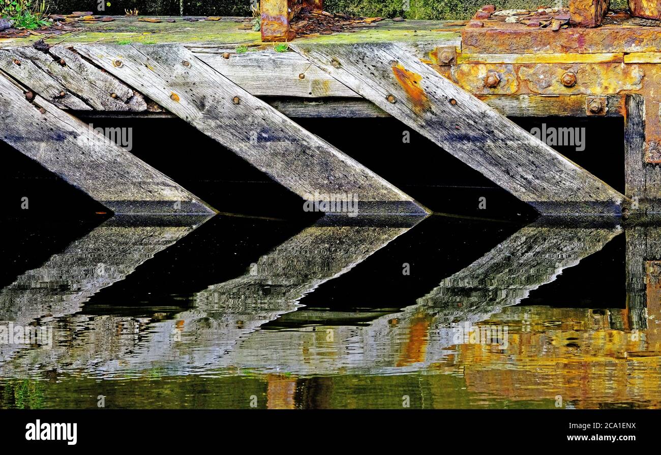 Old dock timbers mirrored into arrow shapes Stock Photo - Alamy