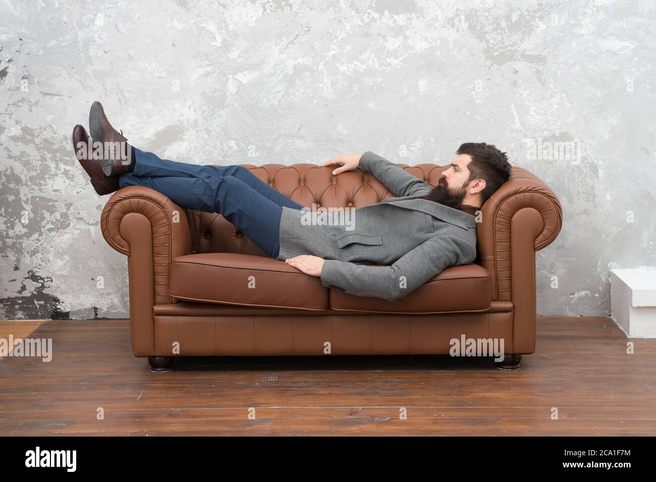 Man relaxing on luxurious leather couch, furniture store concept Stock ...