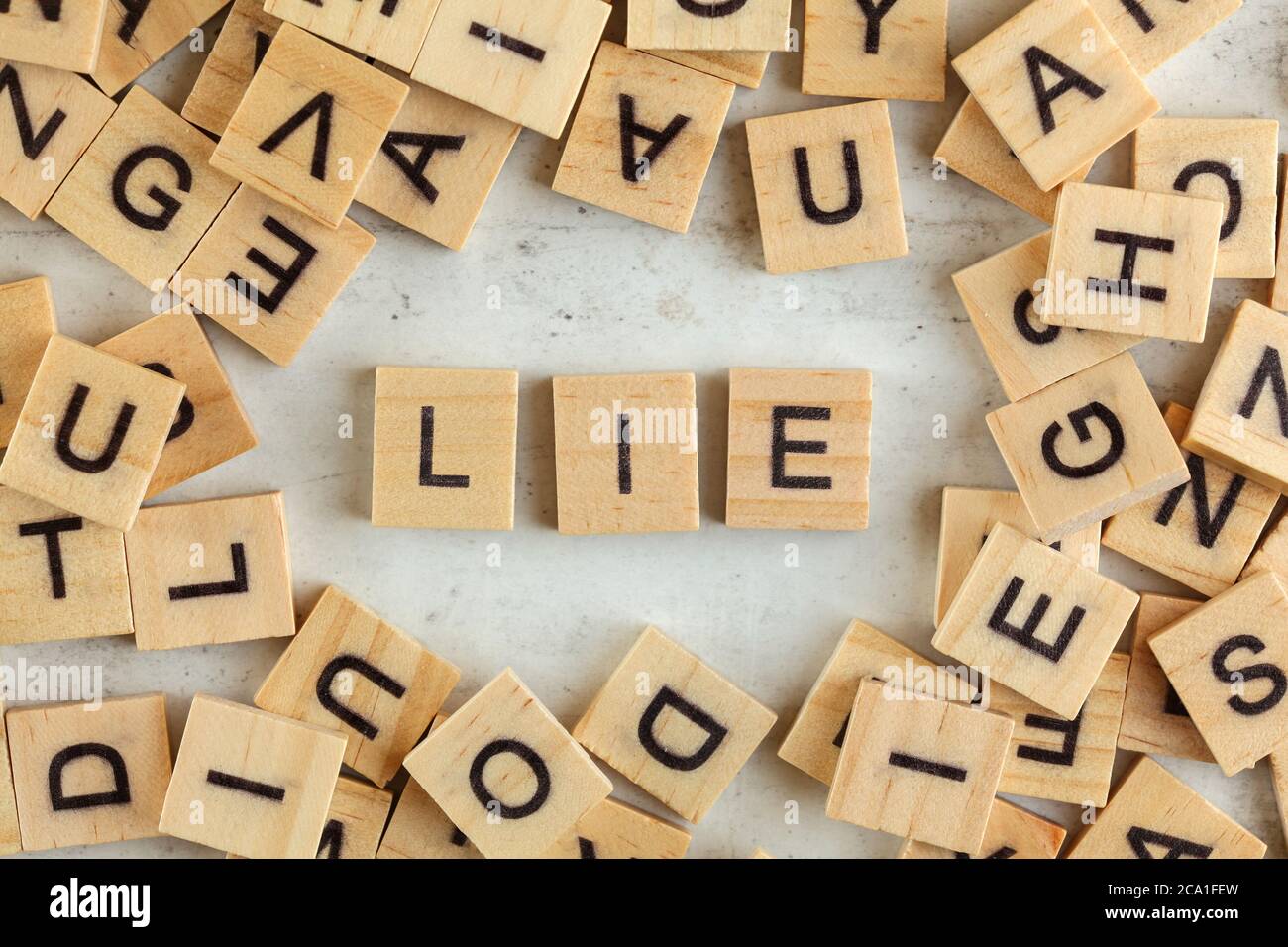 Top down view, pile of square wooden blocks with word LIE on white ...