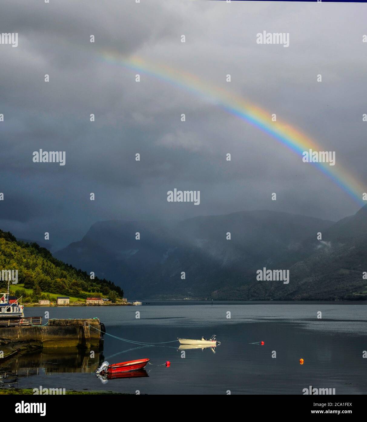 A rainbow over boats in Solvorn, Norway. Solvorn sits at the most ...
