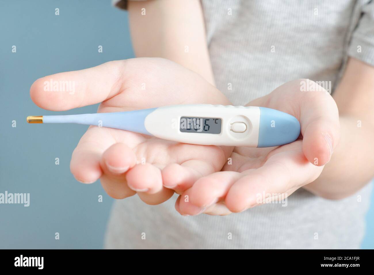 Electronic thermometer in a children's hands. Normal temperature. Close ...