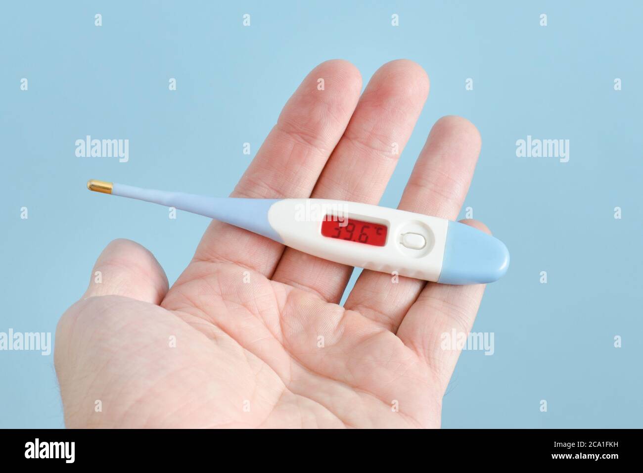 Electronic thermometer in a man's hand. Elevated body temperature ...