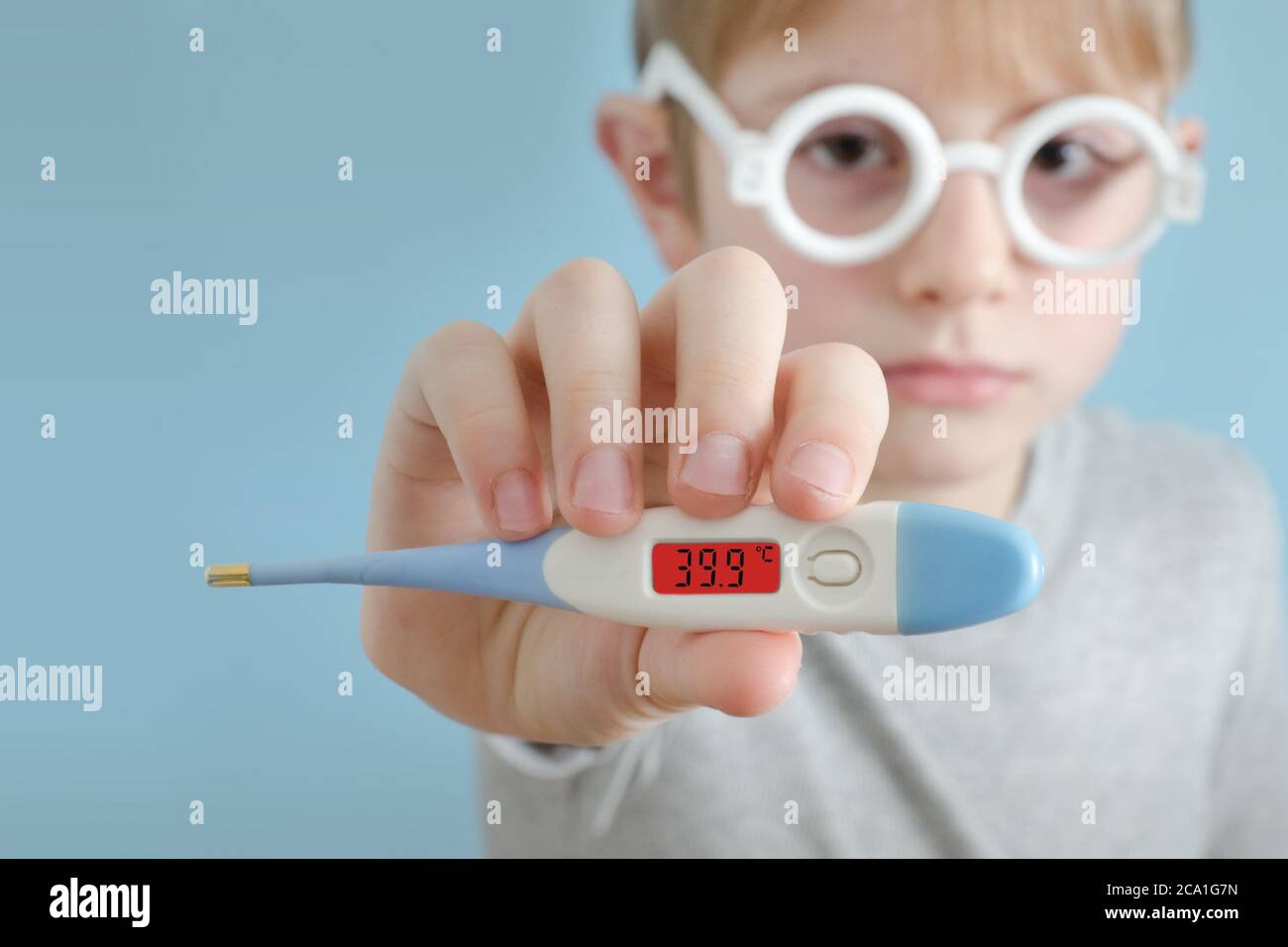 Little boy with a thermometer in his hand. Increased body temperature ...