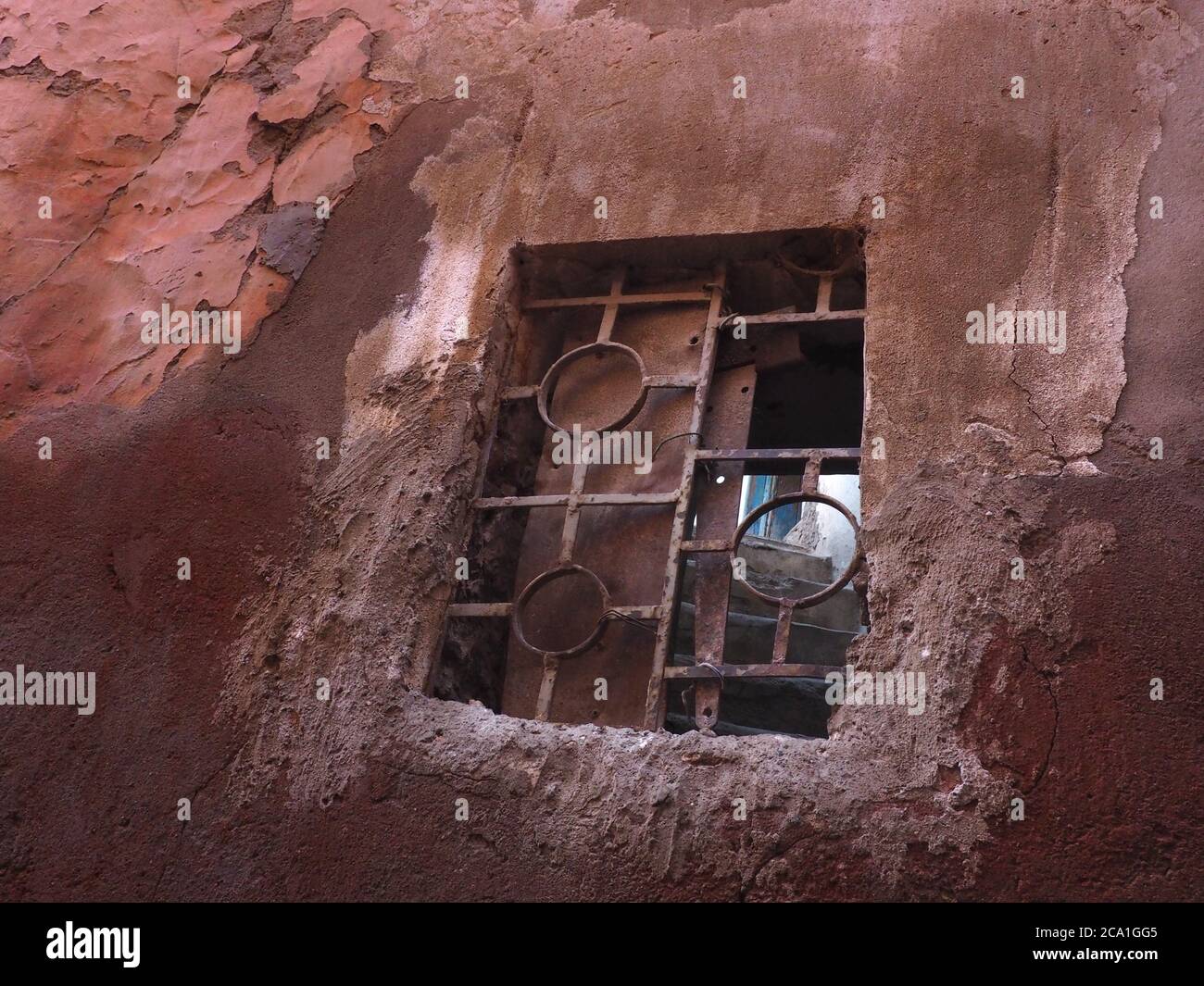 Old window with ancient metal grate on a red wall in the medina of ...