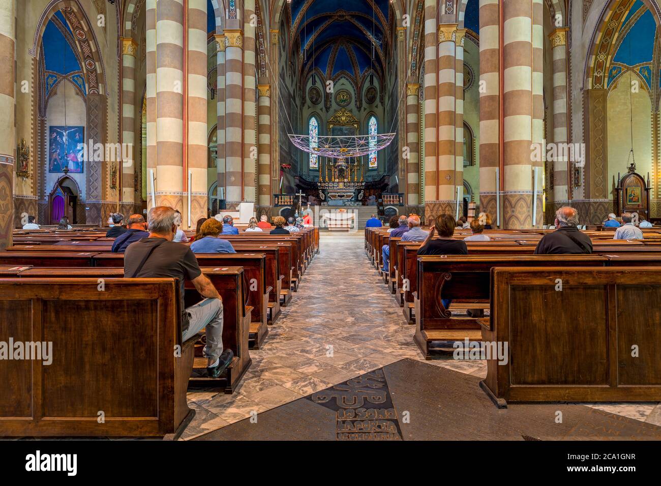 People sitting on wooden pews during mass inside of San Lorenzo - a ...