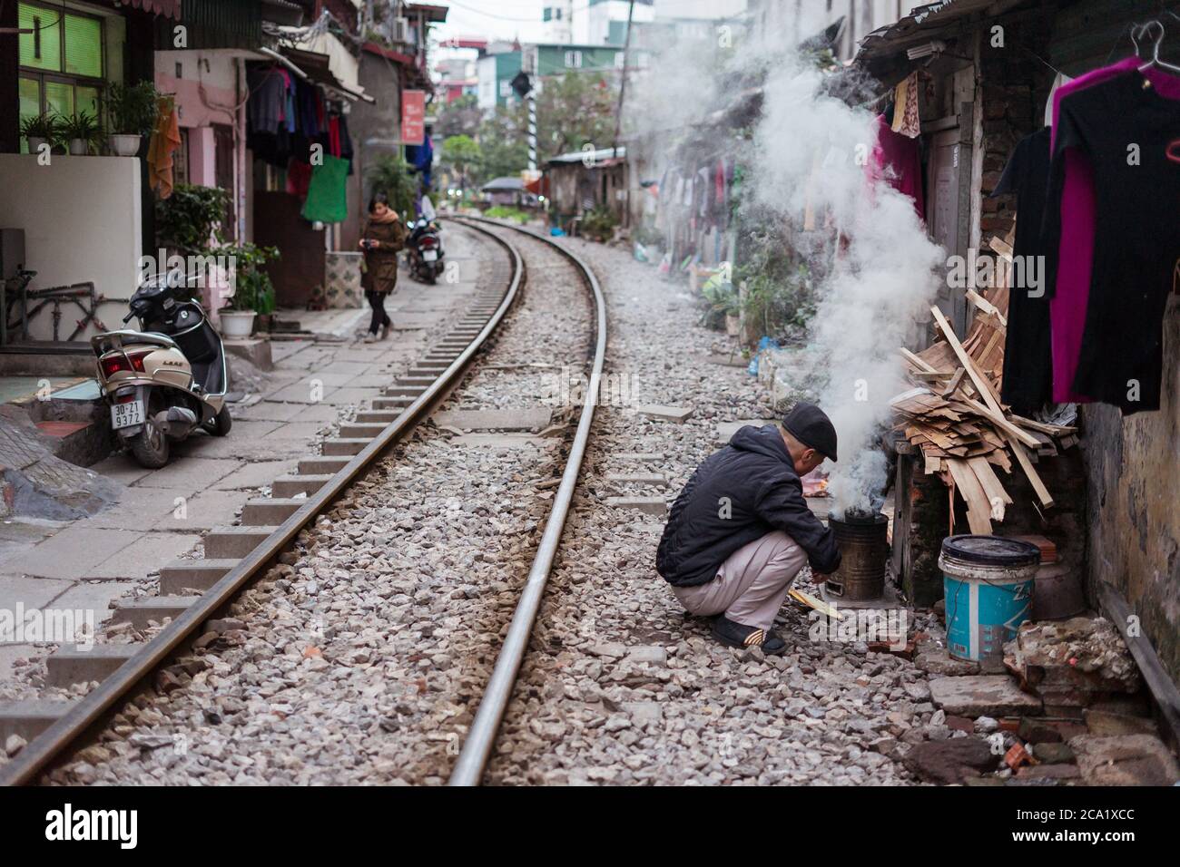 Hanoi / Vietnam - January 21, 2020: man making a fire next to rail ...