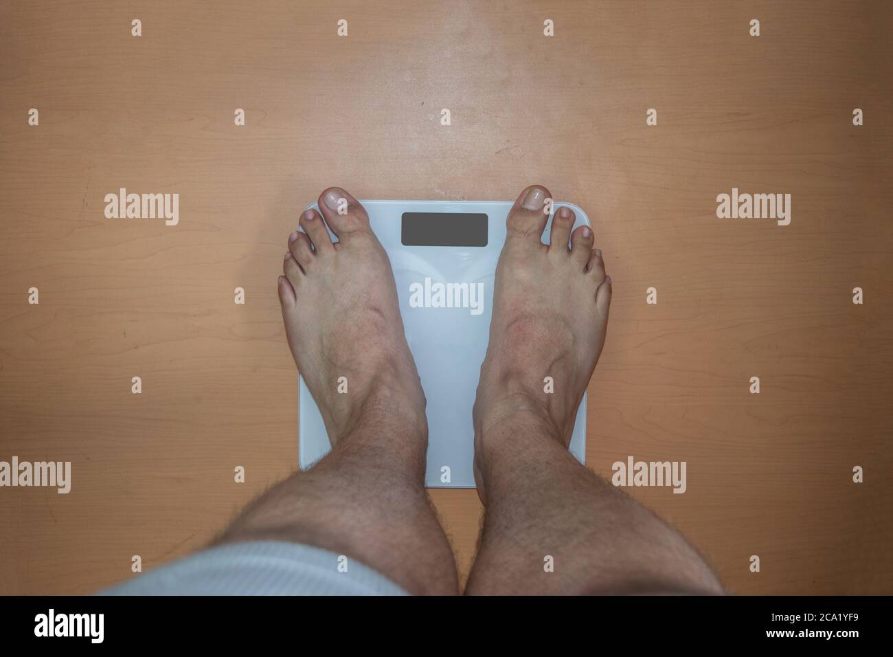 fat man weighing himself on digital scale Stock Photo - Alamy