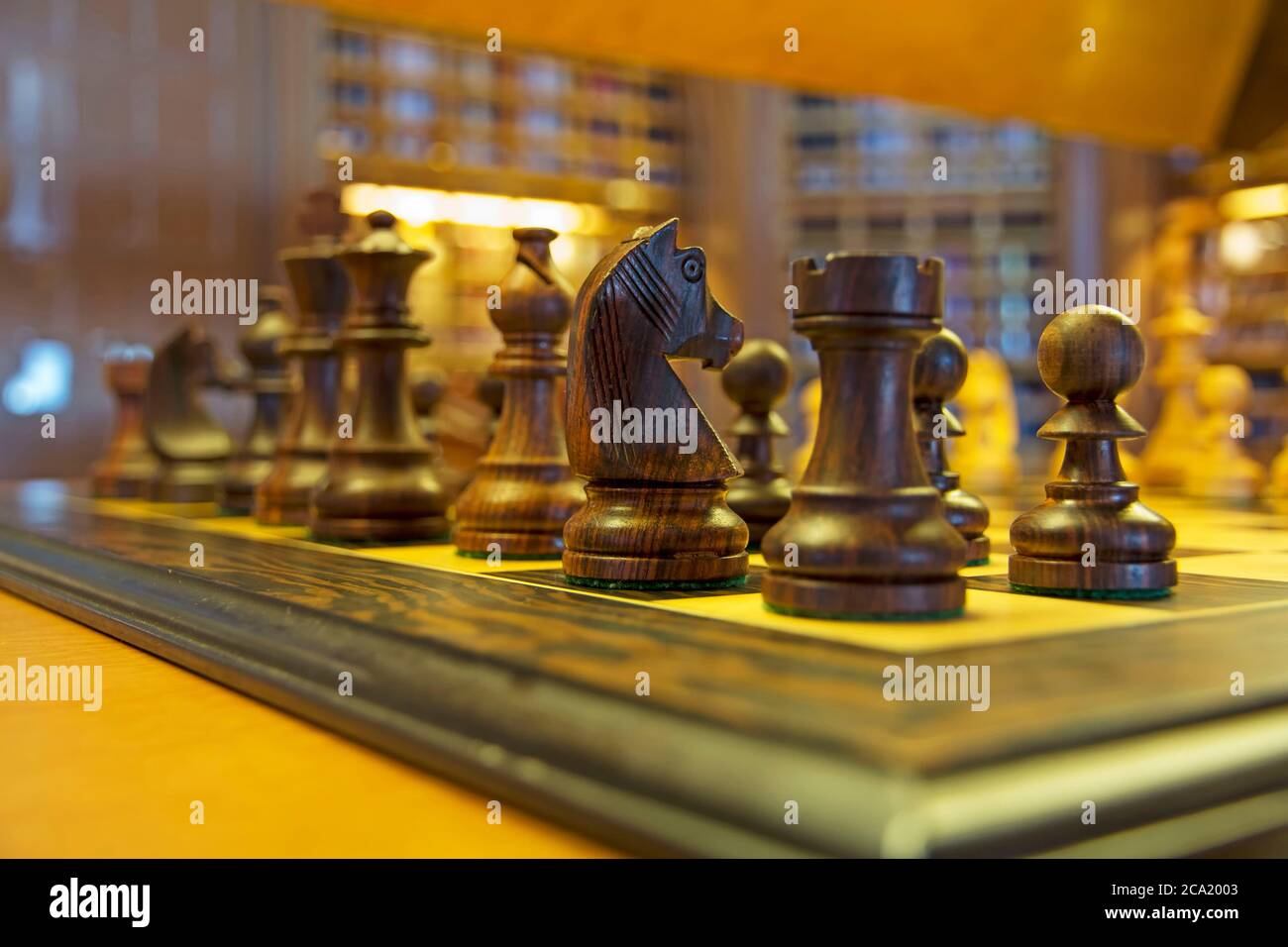 Wooden chess pieces on a chessboard in a ship's library Stock Photo - Alamy