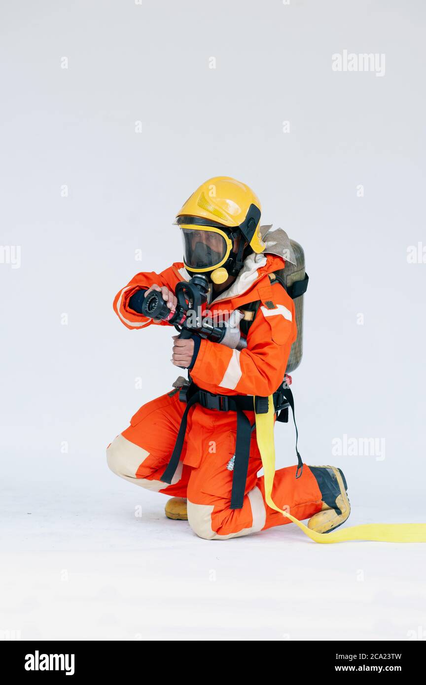 A portrait of Asian male firefighter in red protective uniform, mask ...