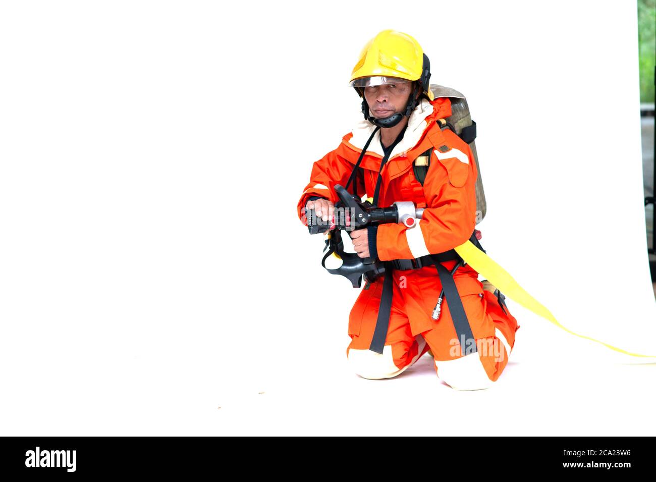 A portrait of Asian male firefighter in red protective uniform, mask ...