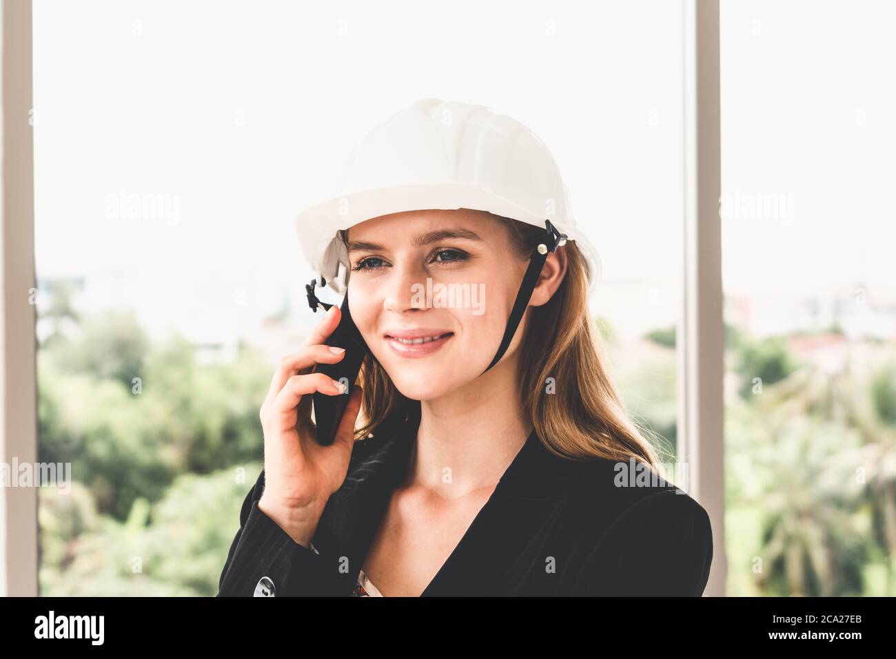 Female engineer on phone and speaking with team Stock Photo - Alamy