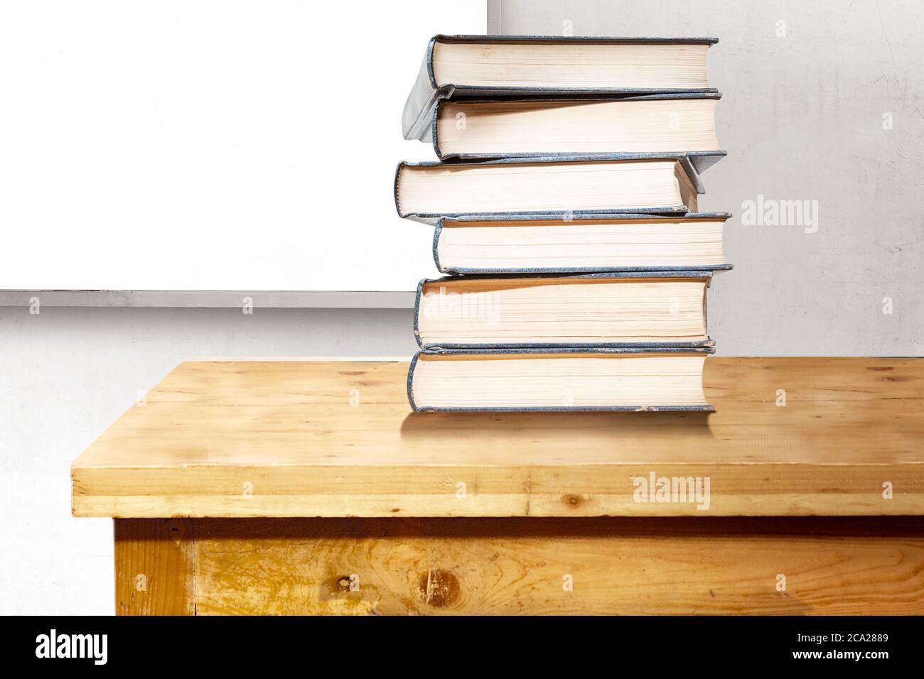 Desk with a stack of books with a whiteboard background. Back to School ...