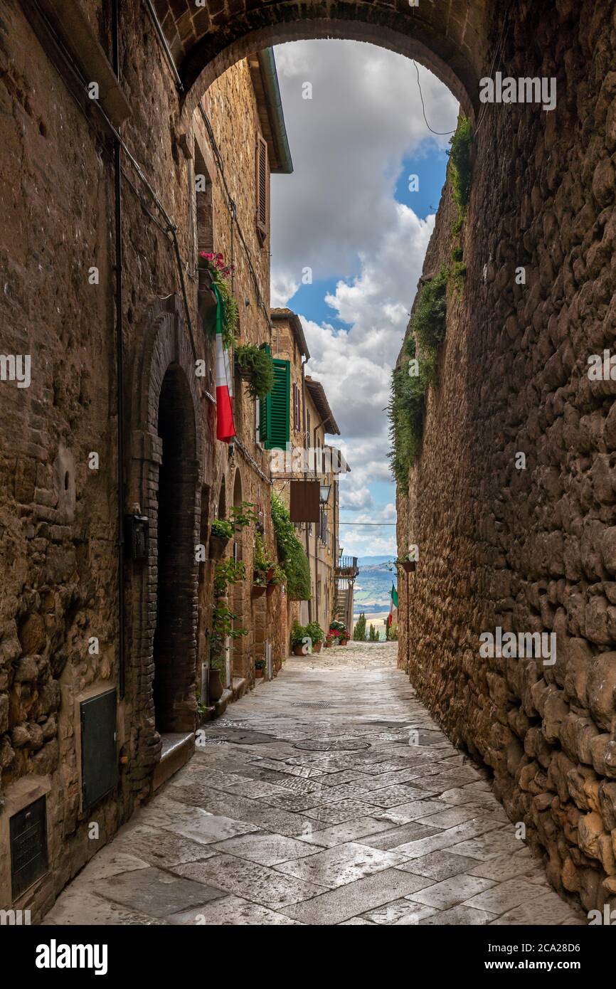 An iconic narrow back alley in the Tuscanian town of Pienza, with ...