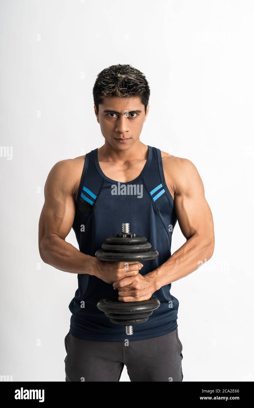 young man wearing gym clothes lift the dumbbell with both hands looking ...