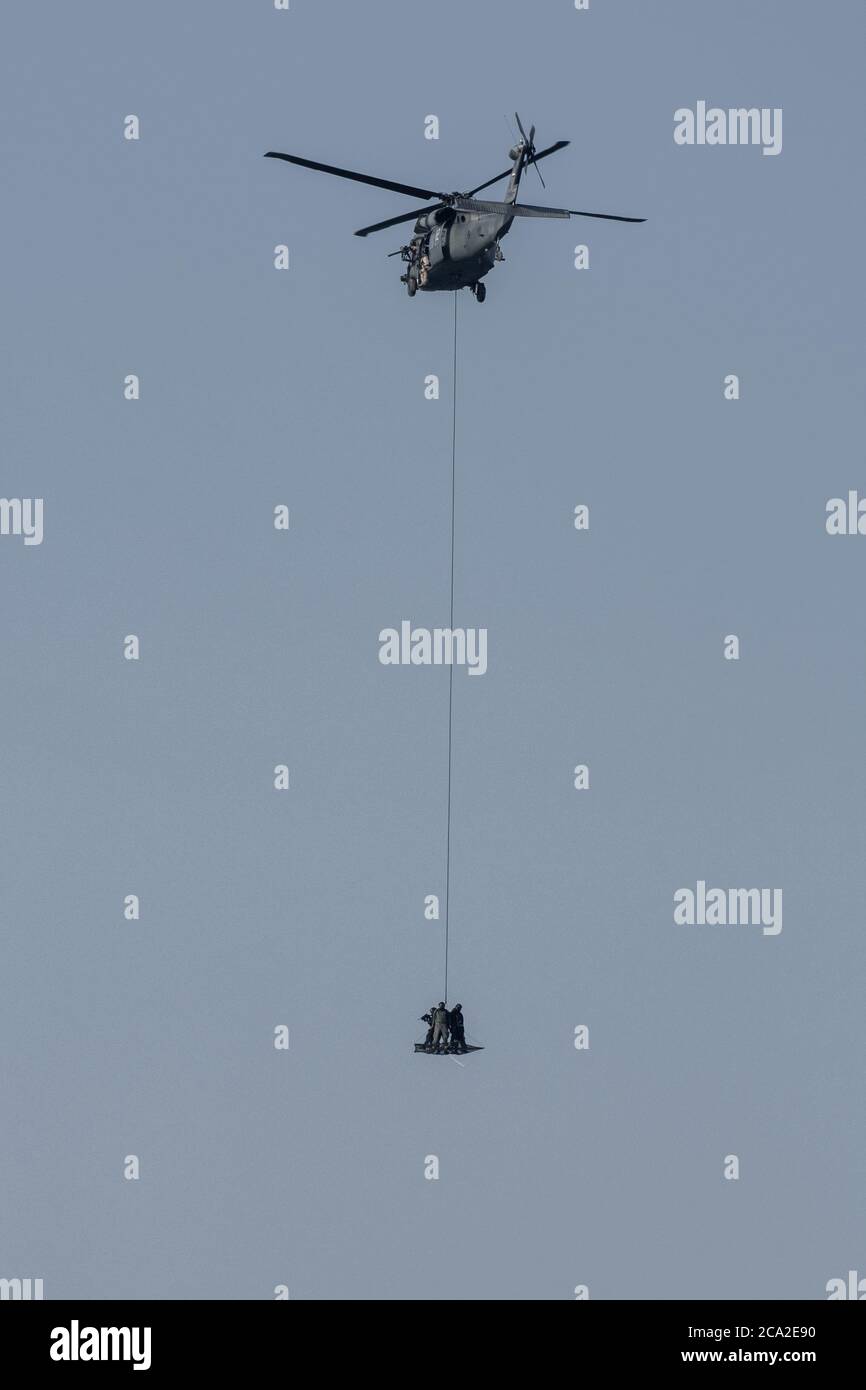 Military team in conflict resucing people by helicopter. flying through ...