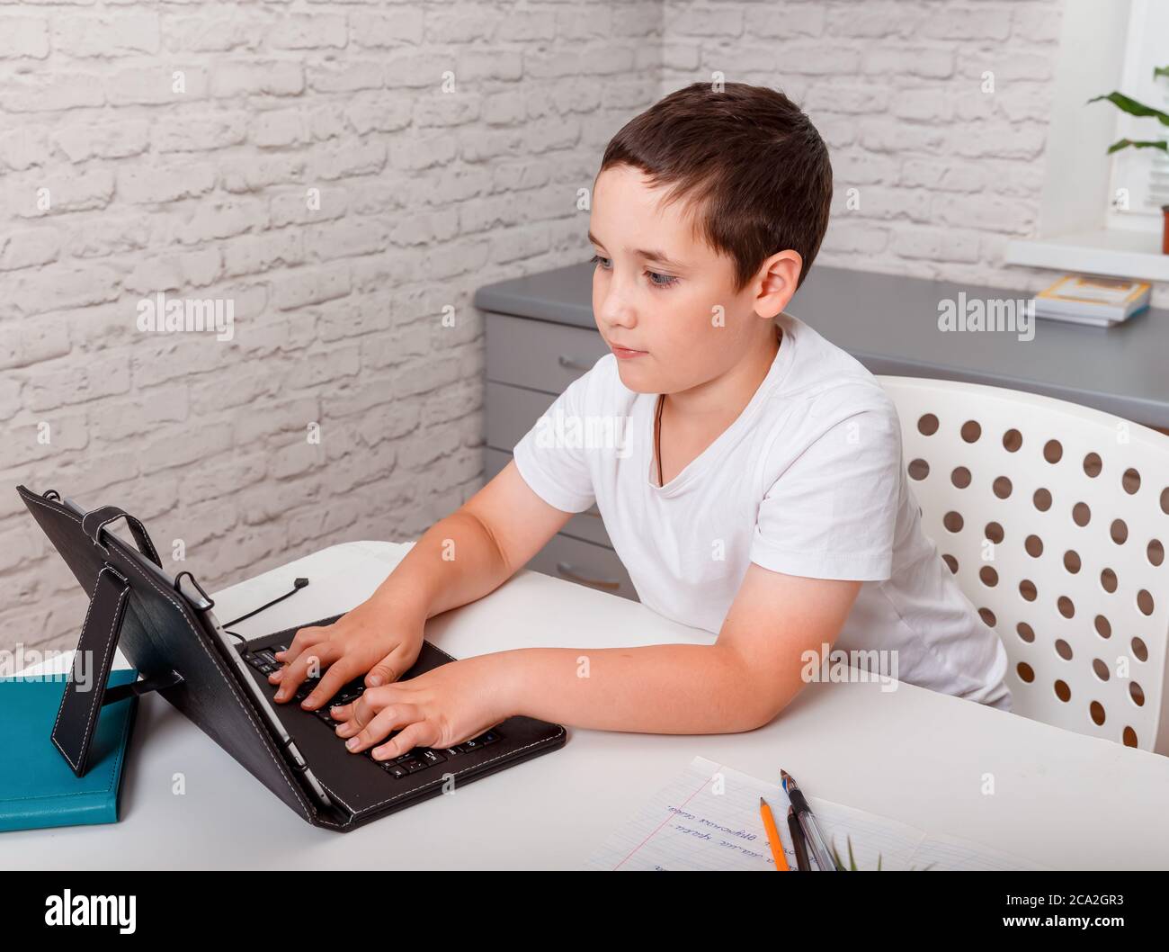 Caucasian boy using tablet pc computer studying homework at home Stock ...