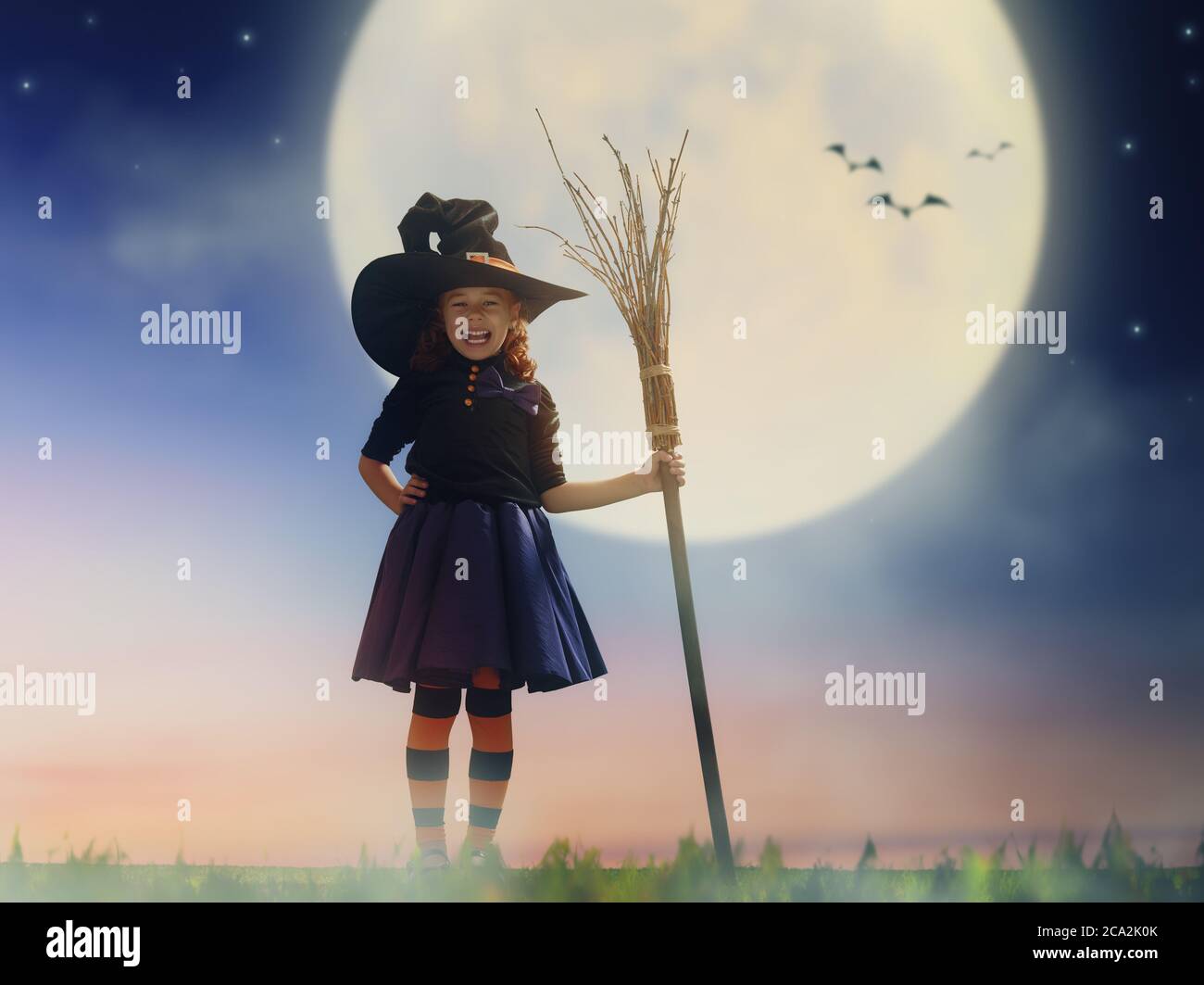 Happy Halloween! Cute little witch with a broomstick. Beautiful young ...