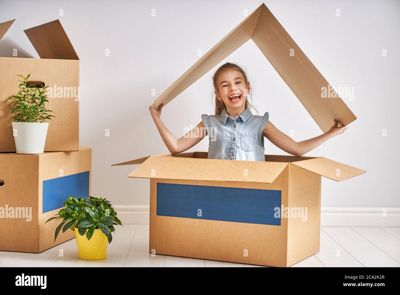 Child girl in the house with a symbol of roof. Concept of housing for ...