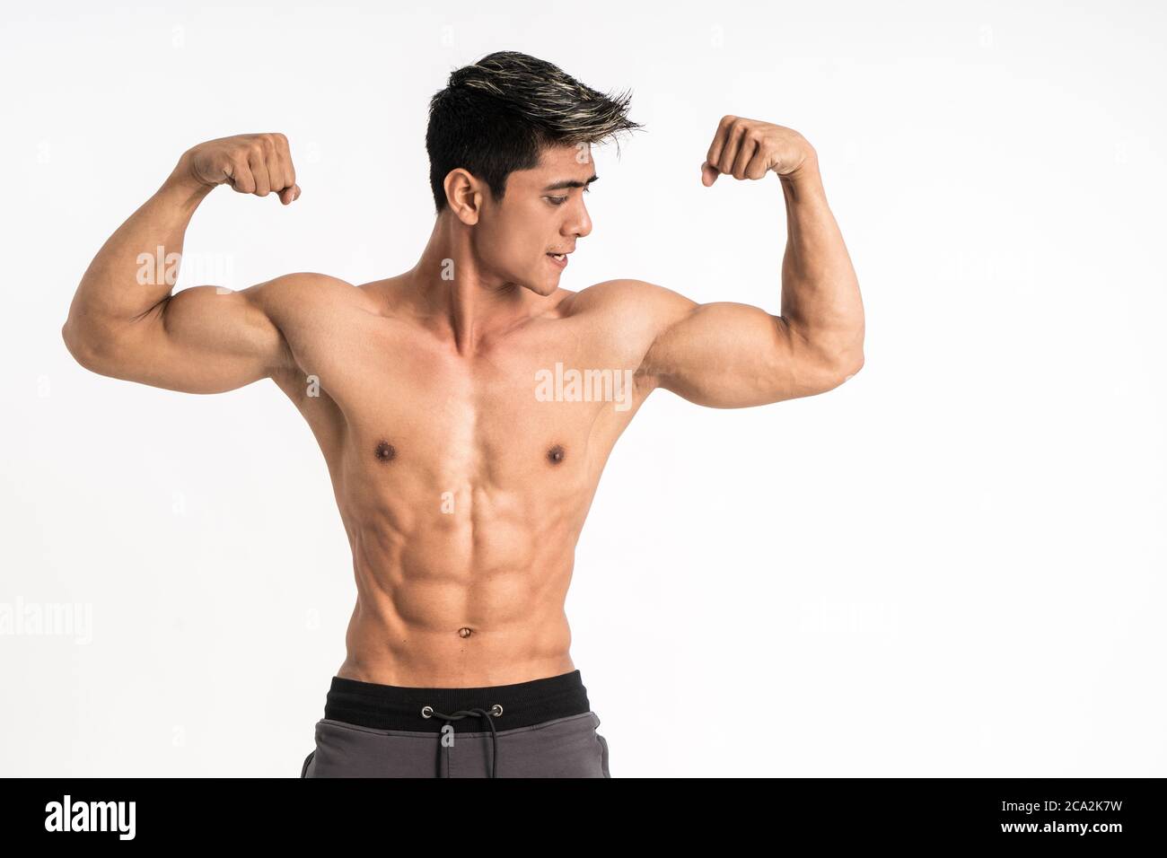 half body image of young man showing muscular biceps stand facing ...