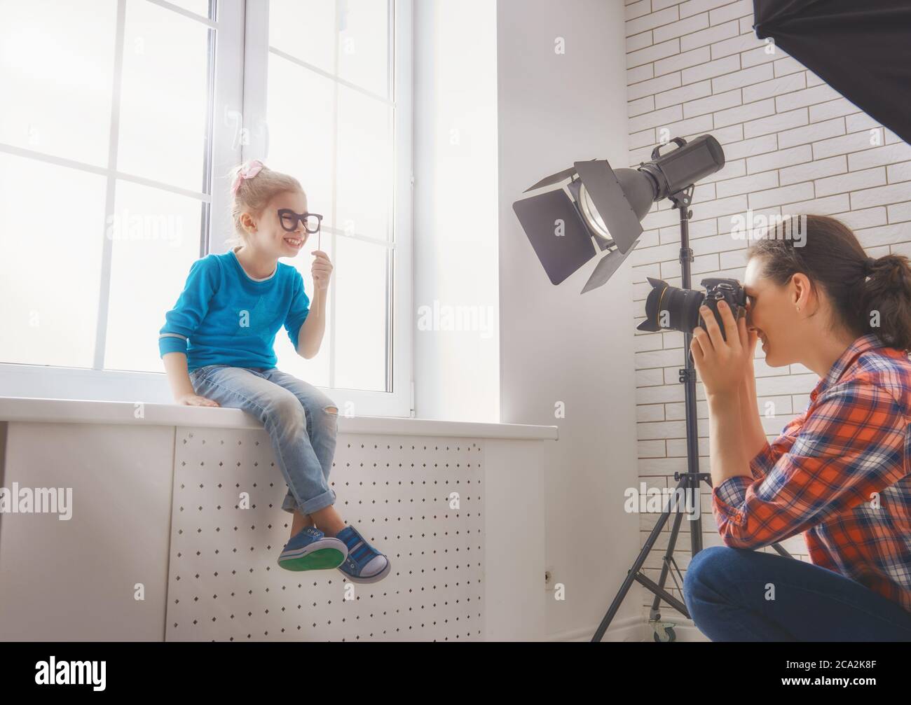Photographer in motion. Young woman photographer and child girl having ...