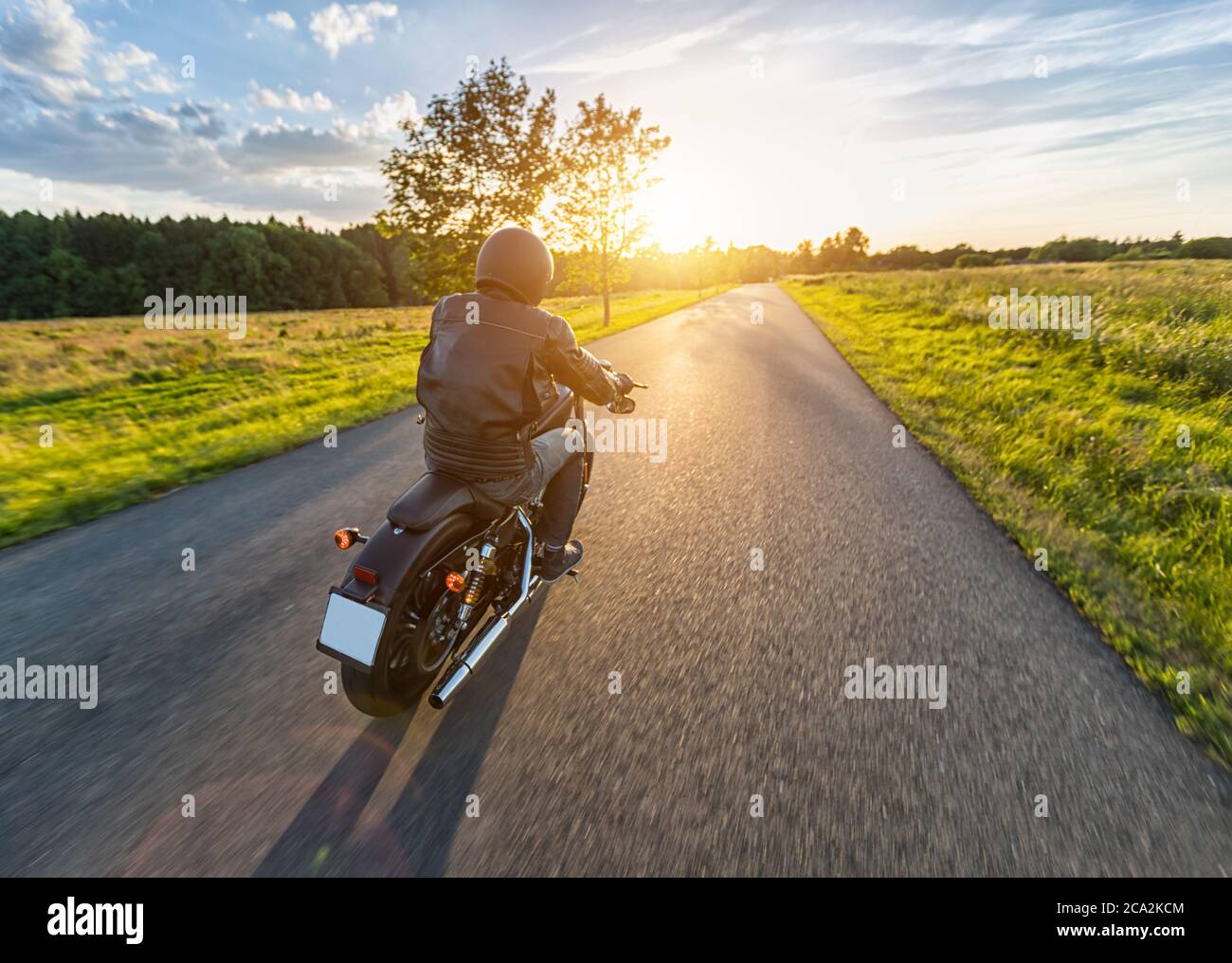 Dark motorbiker riding high power motorbike in nature with beautiful ...