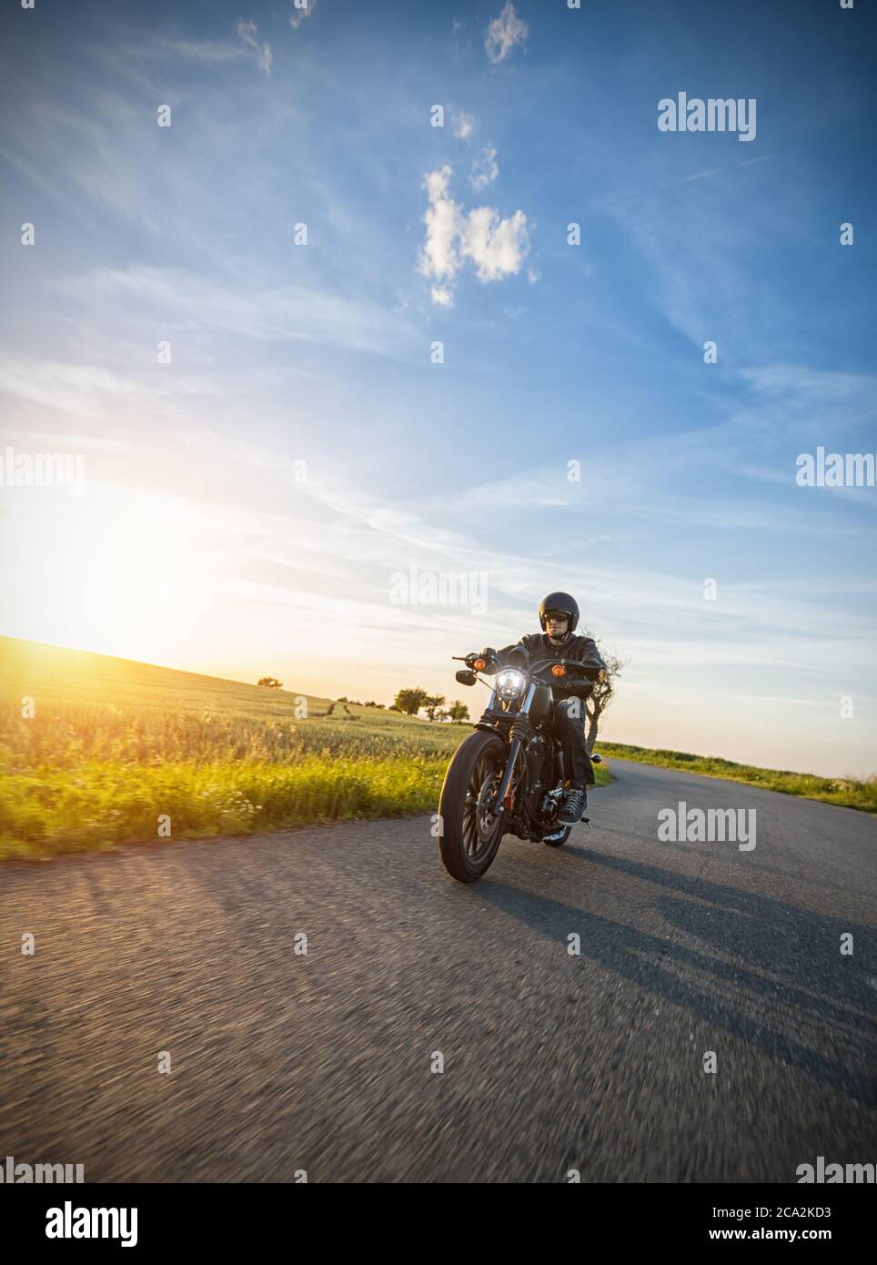 Dark motorbiker riding high power motorbike in nature with beautiful ...