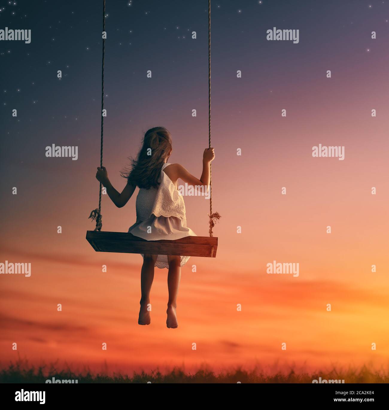 Happy child girl on swing in sunset summer Stock Photo - Alamy