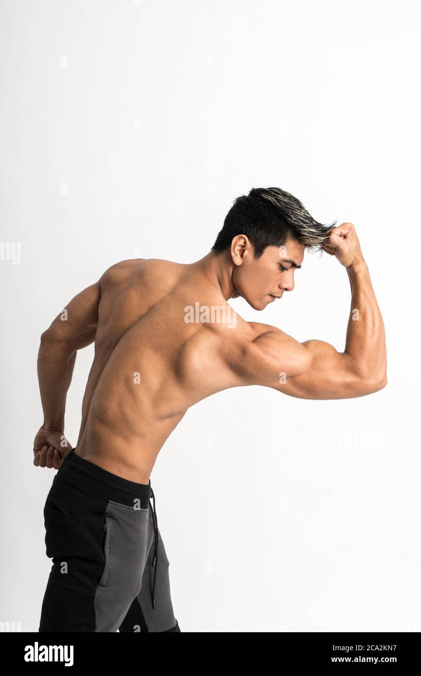 half body image of young man showing muscular biceps stand facing ...