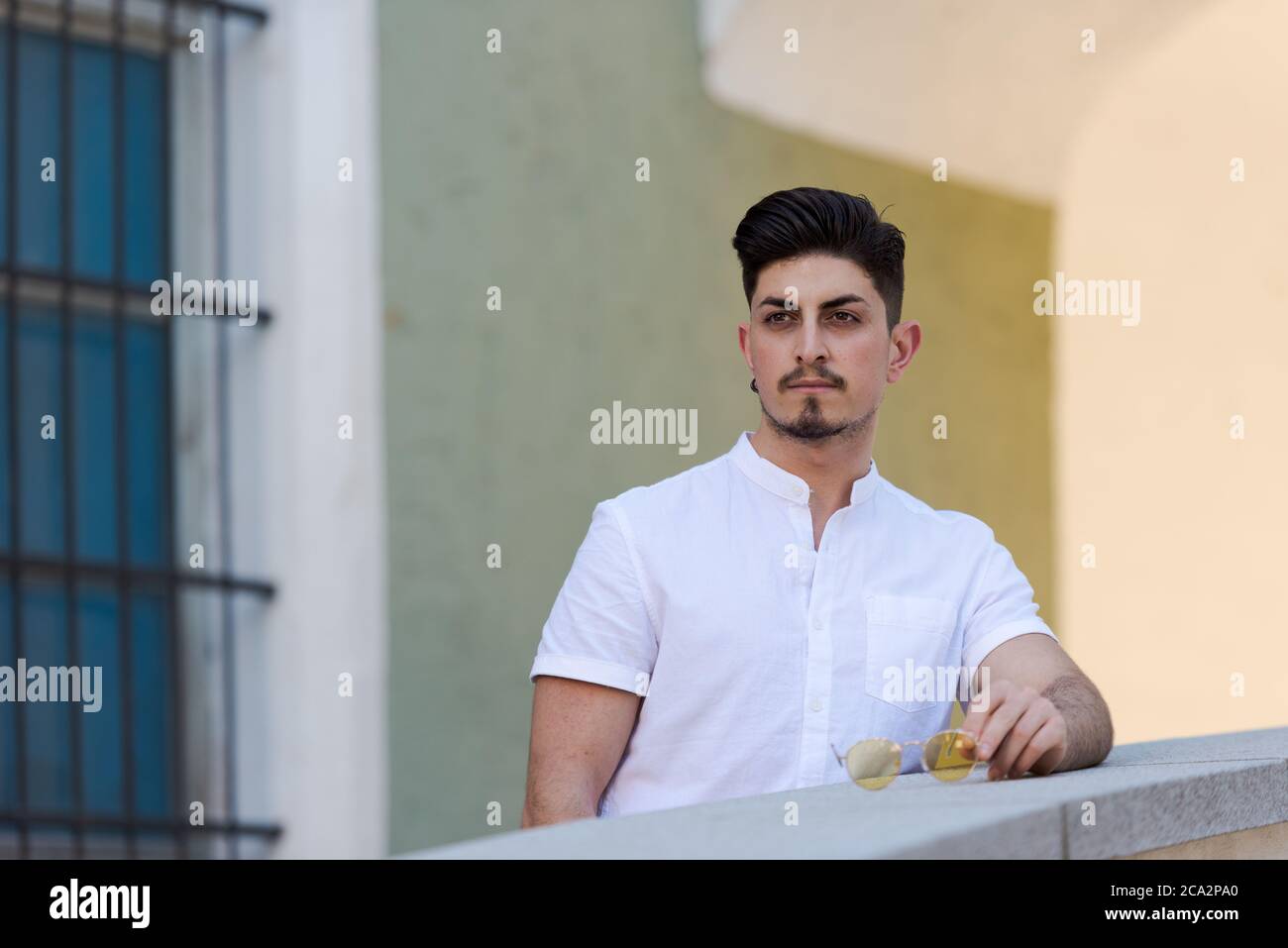 Young styled arabic man with black hair and goatee in white shirt ...