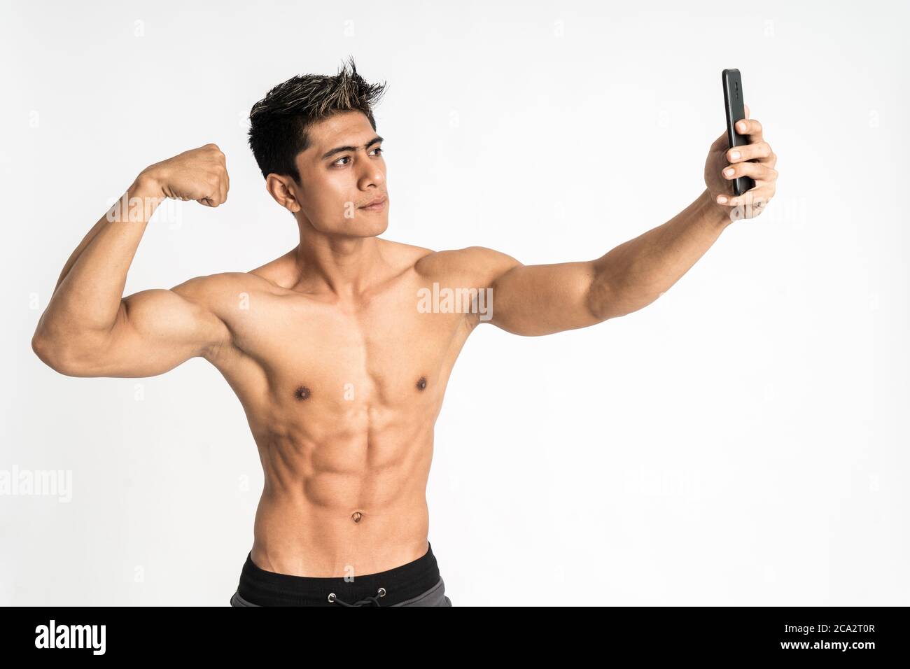 young man with muscular body holding a smartphone for selfie with one ...