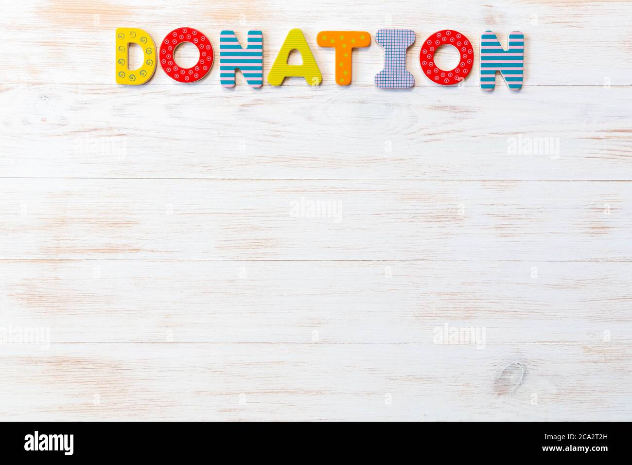 Word DONATION of colorful wooden letters on wood background. Donation ...