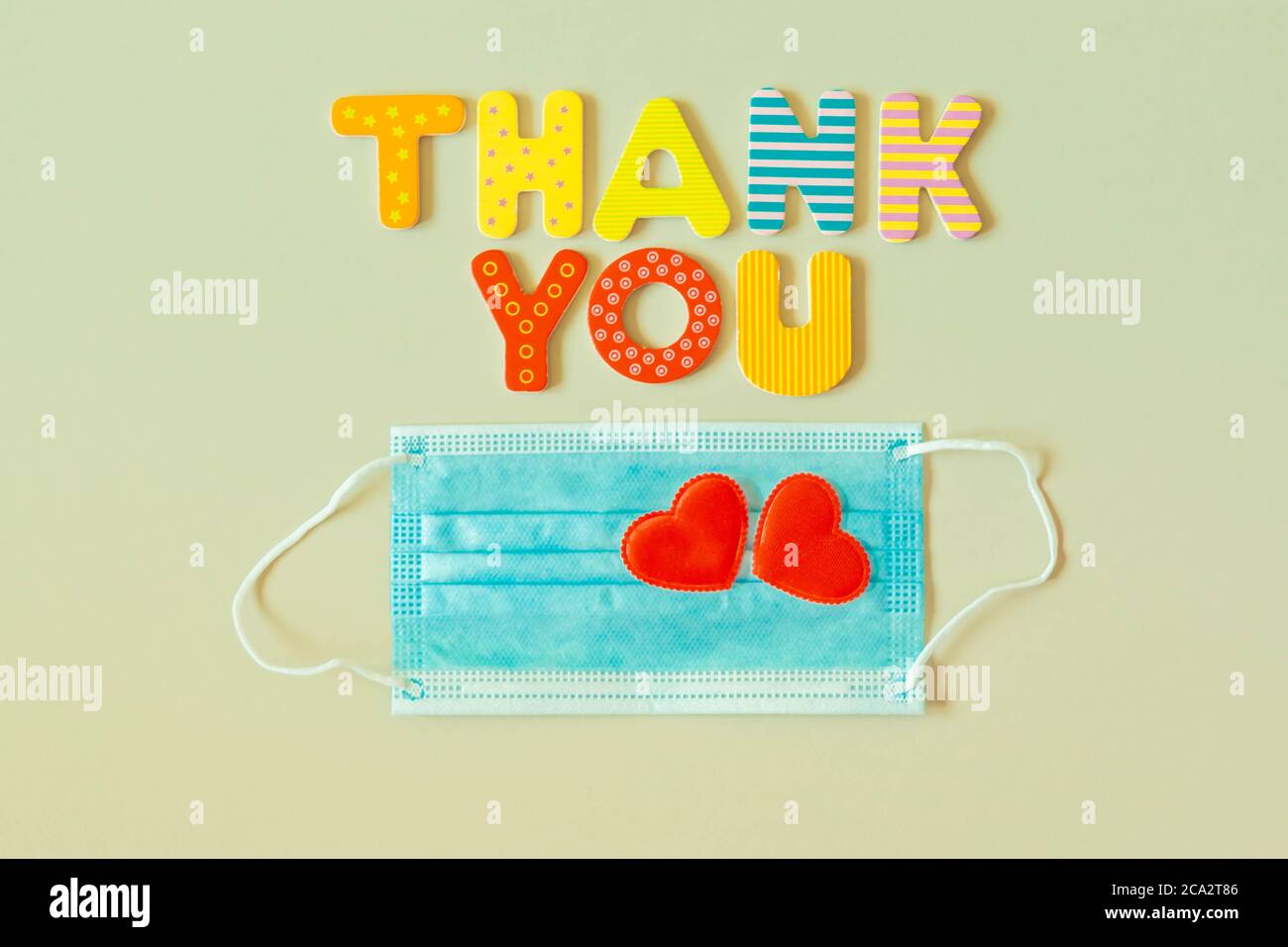 Heart symbols on disposable medical mask and text THANK YOU of wood ...