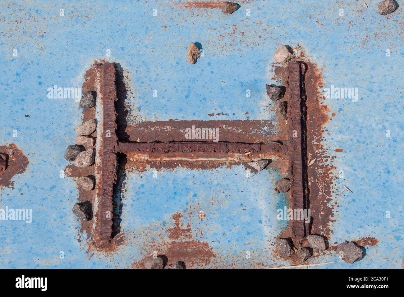 A rusty metal letter H with a textured blue painted background Stock ...