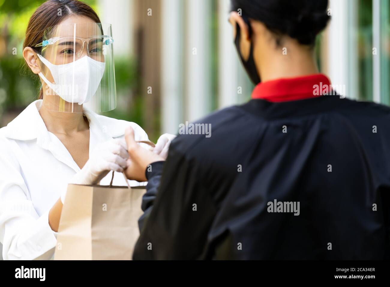 Portrait of atrractive asian woman give bakery grocery bag to delivery ...