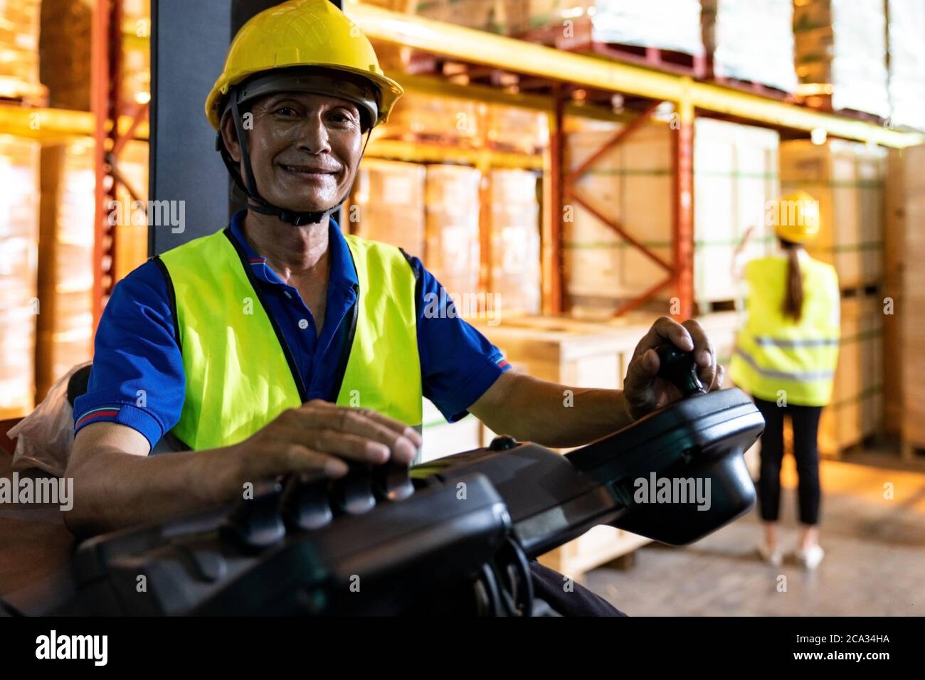 Portrait asian male warehouse worker using forklift truckin large ...