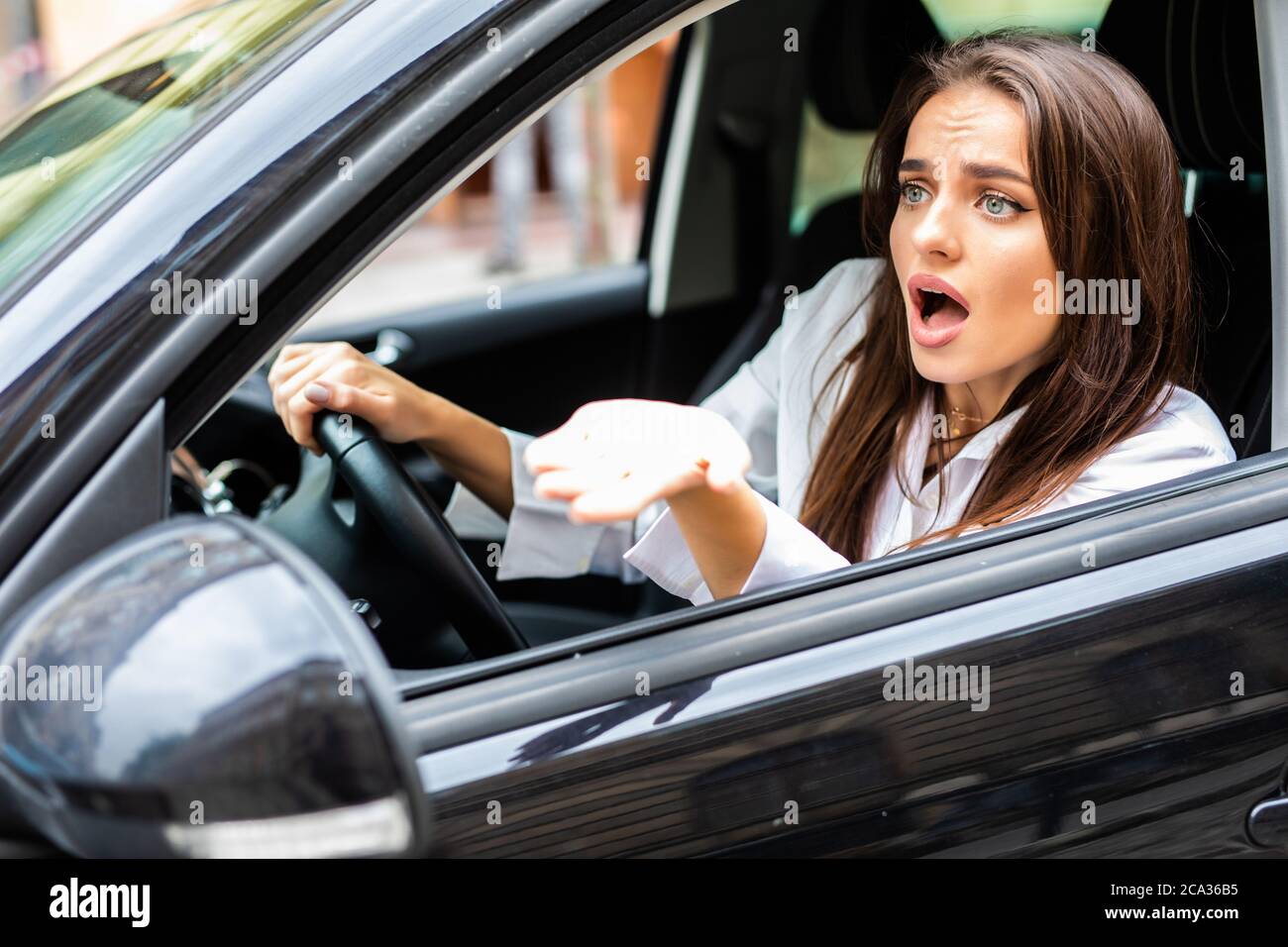 Beautiful angry woman honking in her car while driving Stock Photo - Alamy
