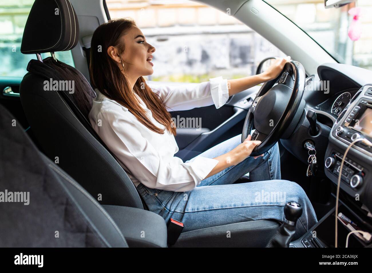 Side View Of A Young Happy Woman Driving Car Stock Photo - Alamy