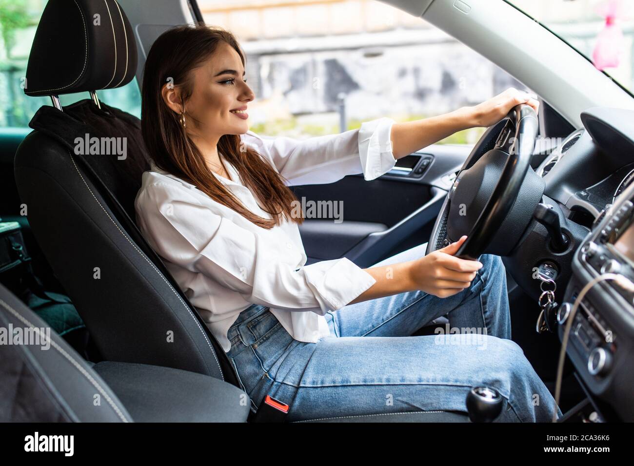Side View Of A Young Happy Woman Driving Car Stock Photo - Alamy