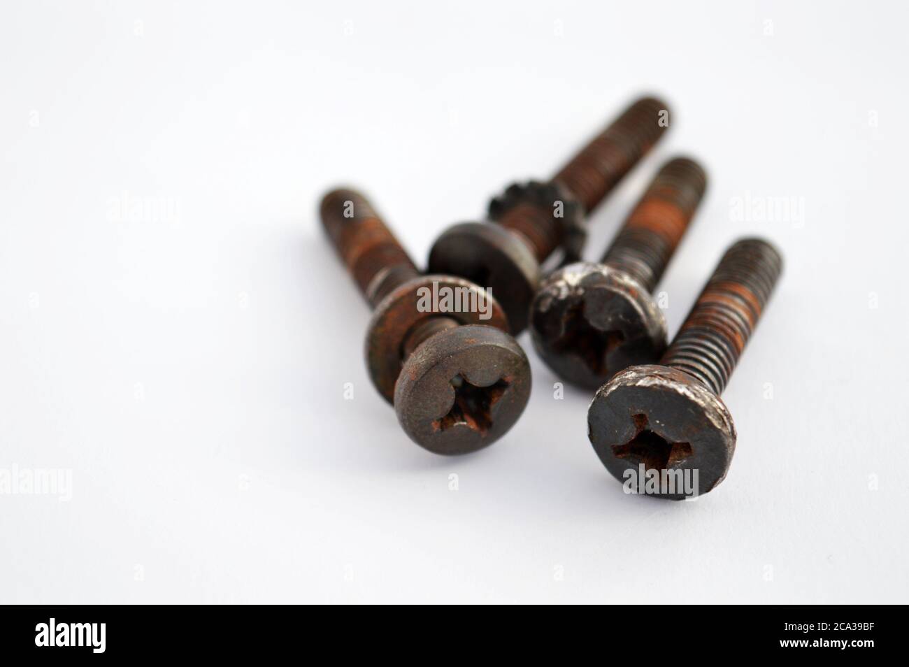 four old and rusty bolts on white background Stock Photo - Alamy