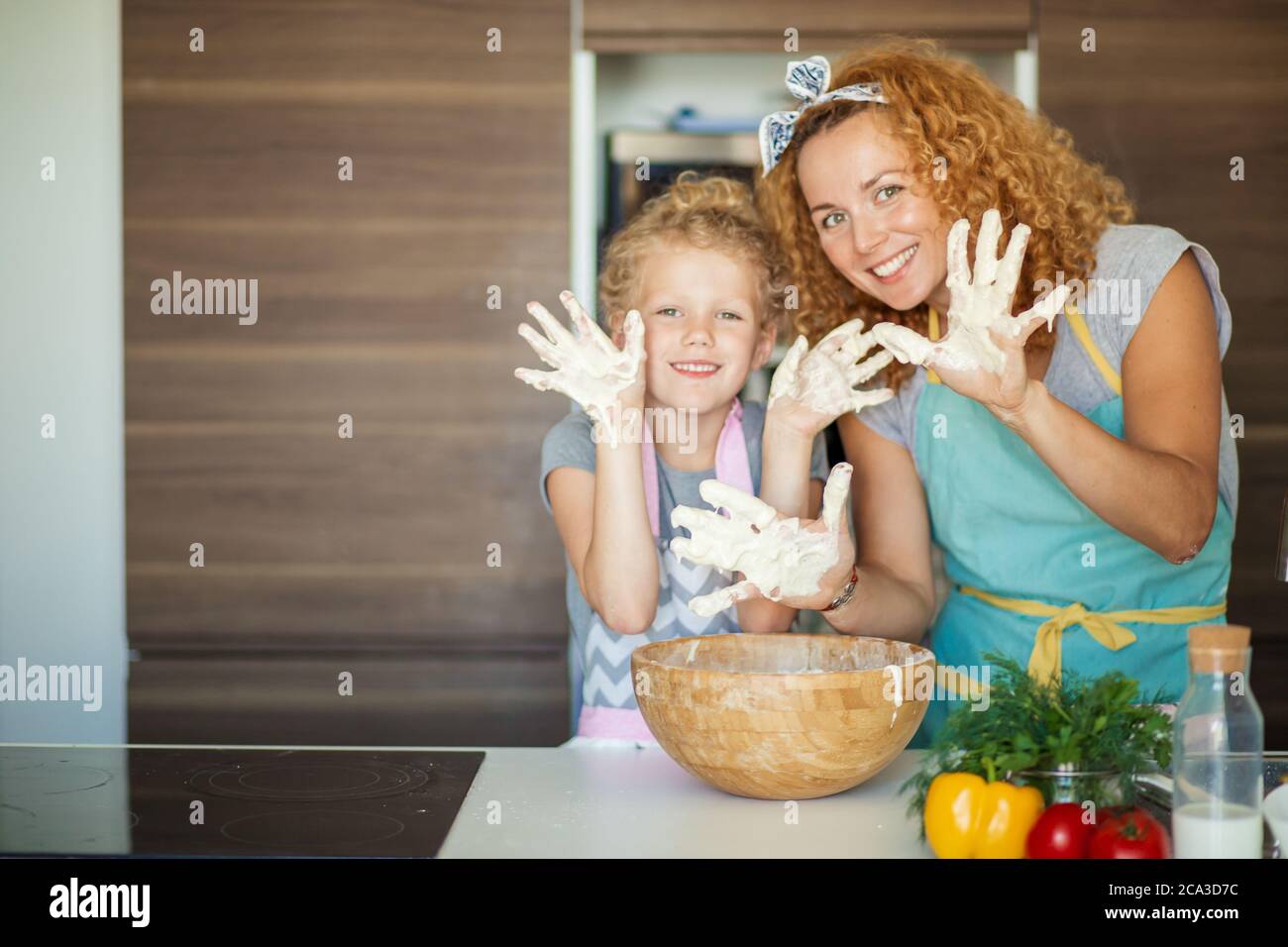Happy loving caucasian Mom and daughter preparing bakery together ...